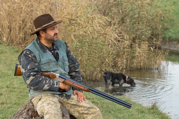 Hunter man in camouflage with a gun during the hunt in search of wild ...