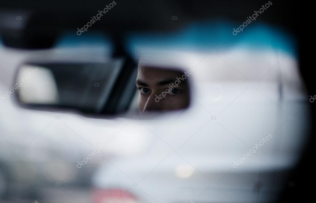 Hombre mirando en el espejo retrovisor mientras conduce: fotografía de ...
