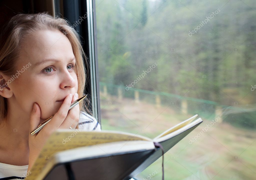 Young woman on a train writing notes Stock Photo by ©danr13 48782201