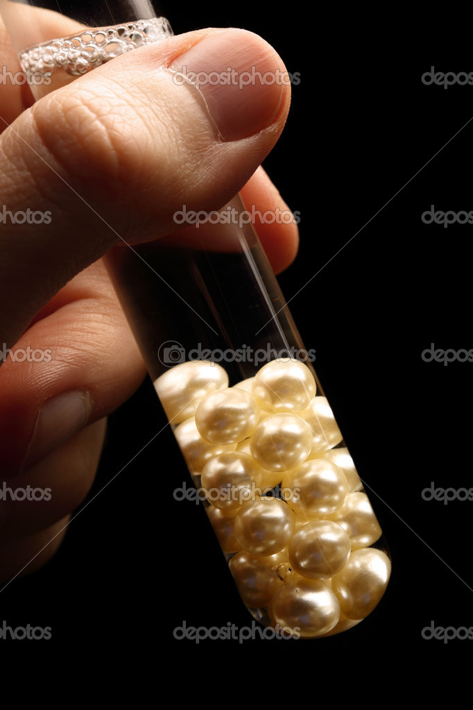 Hand holding test tube with white pearls — Stock Photo © Garsya #23280074