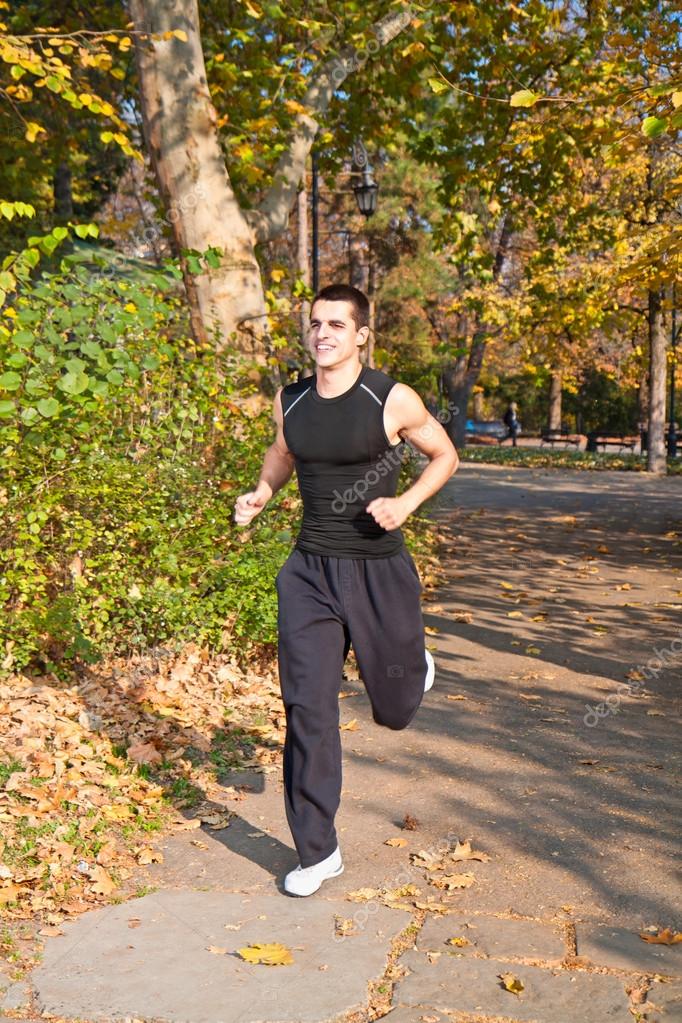 Young man running in a beautiful park — Stock Photo © master2 #20152441