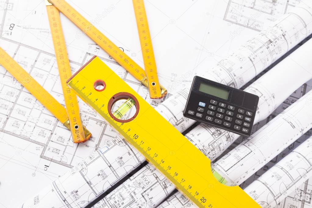 Construction tools with metric folding ruler and architectural drawings ...