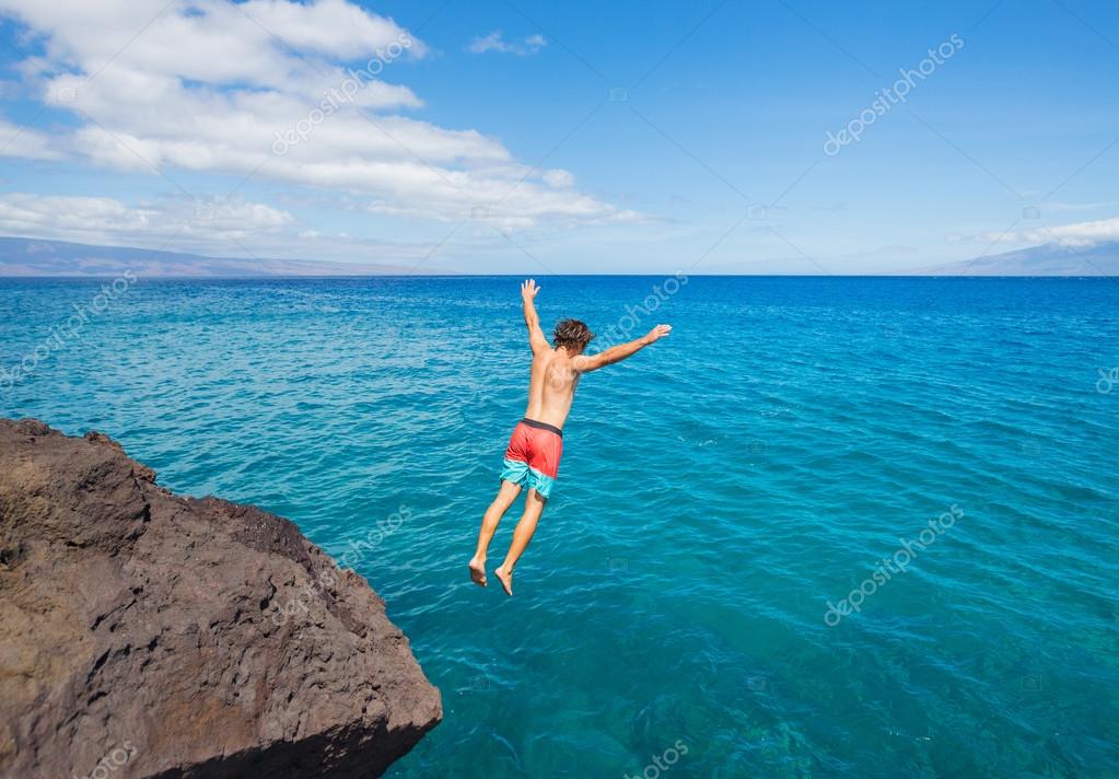 Man jumping off cliff into the ocean — Stock Photo © EpicStockMedia ...