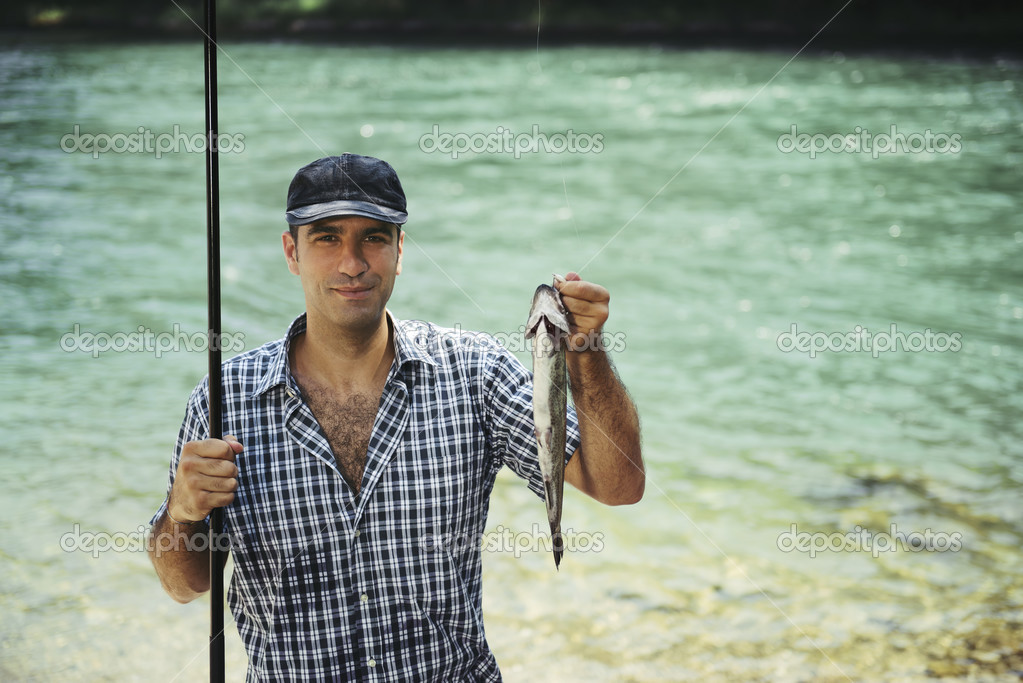 Man fishing on river and showing fish to the camera Stock Photo by ...