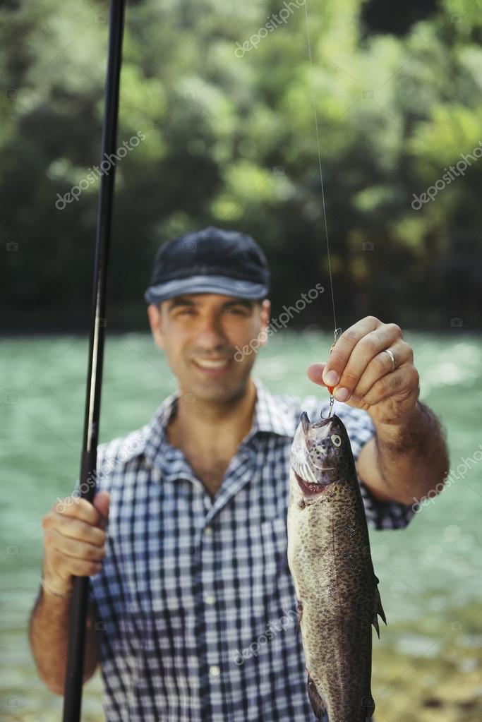 hombre pescando en el río y mostrando peces a la cámara 2022