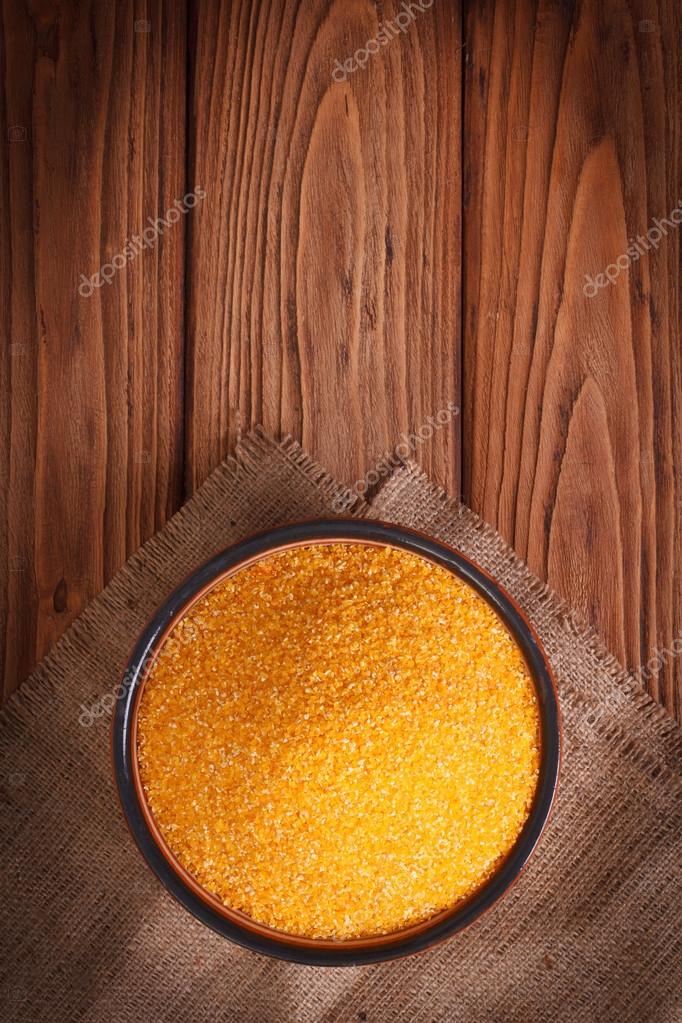 Corn groats in a bowl on a wooden table. top view Stock Photo by ...