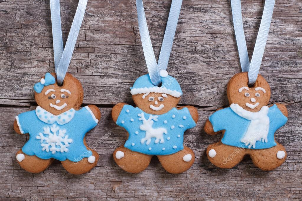 Three blue gingerbread men. Girl with bow and two boys — Stock Photo ...