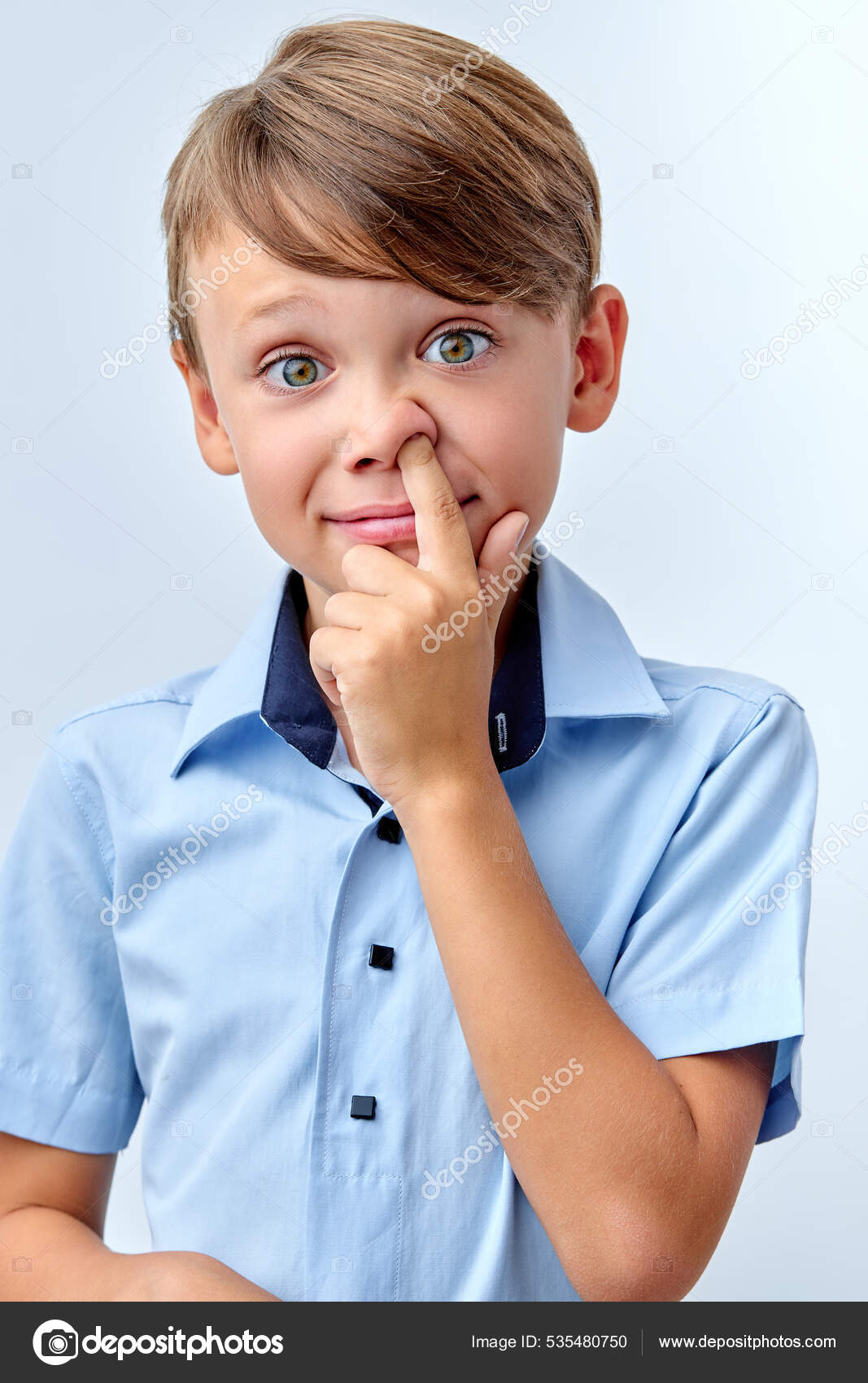 Boy pokes nose with finger. Caucasian kid pulls out the boogers. Bad ...