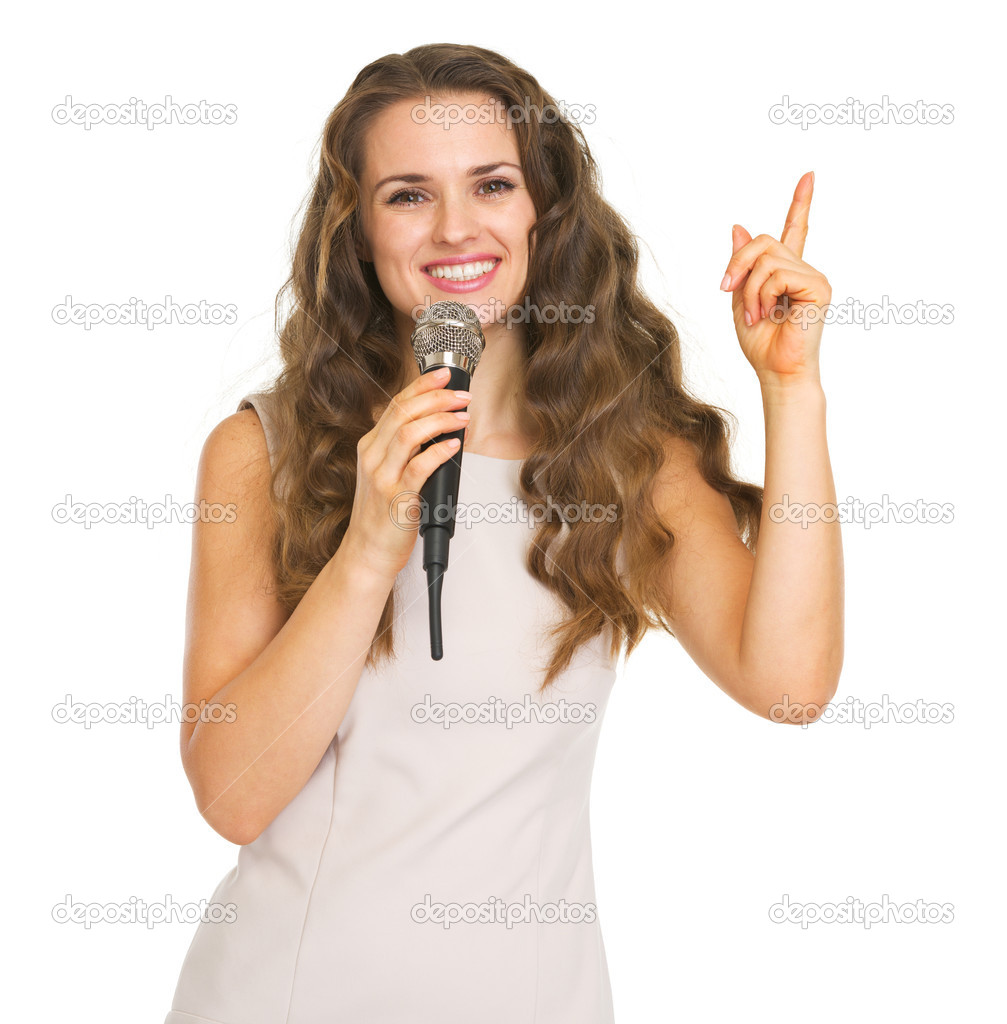Smiling young woman with microphone pointing up on copy space — Stock ...