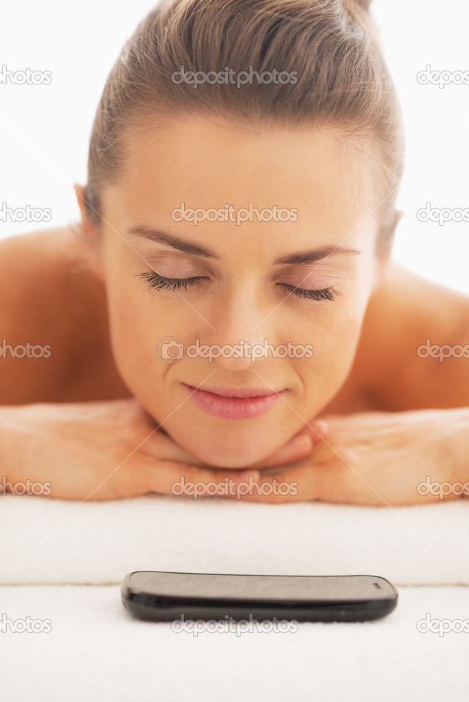 Relaxed young woman and cell phone laying on massage table Stock Photo ...
