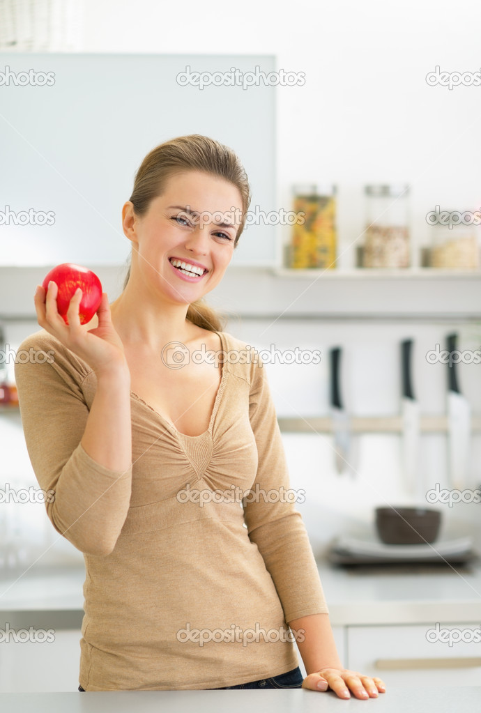 Young woman apple in kitchen Stock Photo by ©CITAlliance 47471037