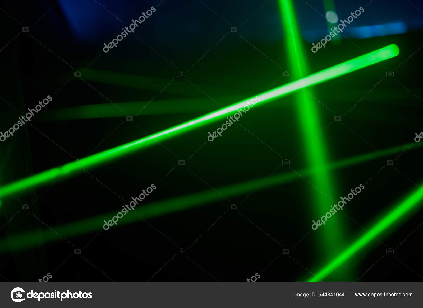 Bright green neon laser lights illuminate the darkness creating lines ...