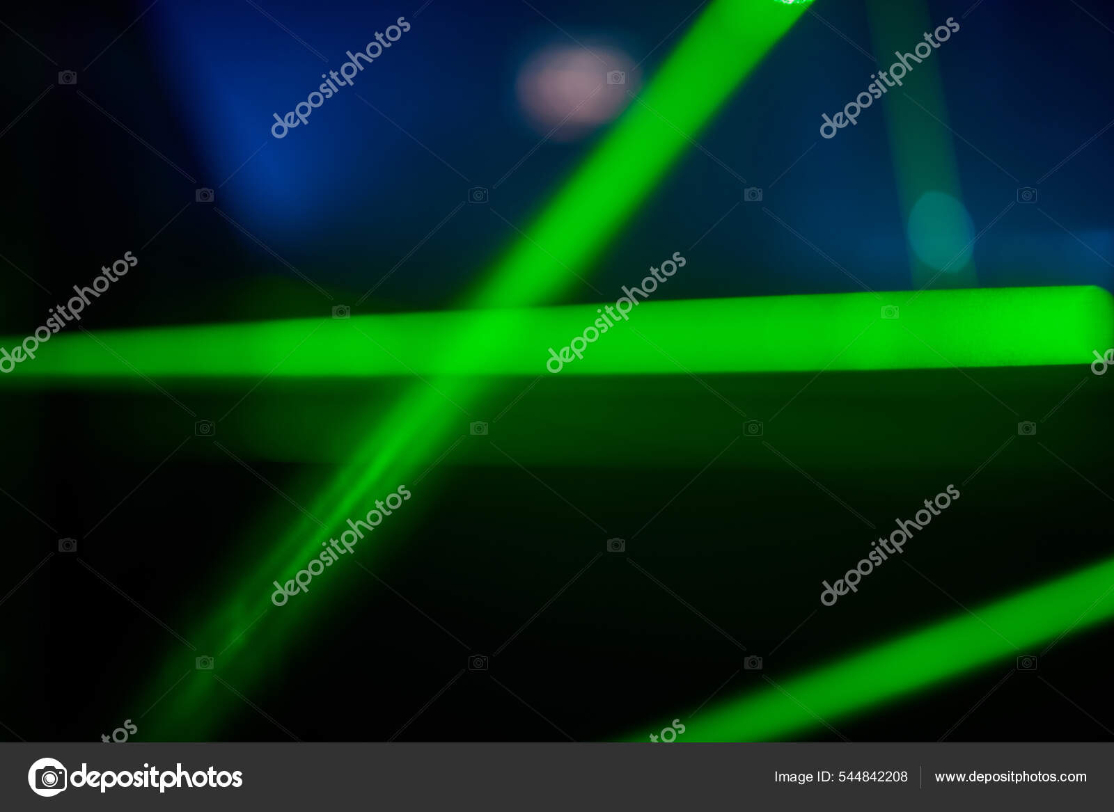Bright green neon laser lights illuminate the darkness creating lines ...