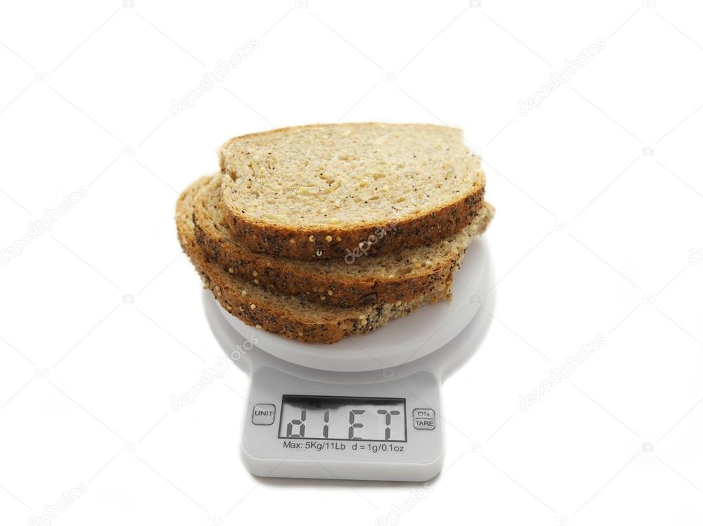 Tower of sliced wholegrain bread on white scales with diet word ...