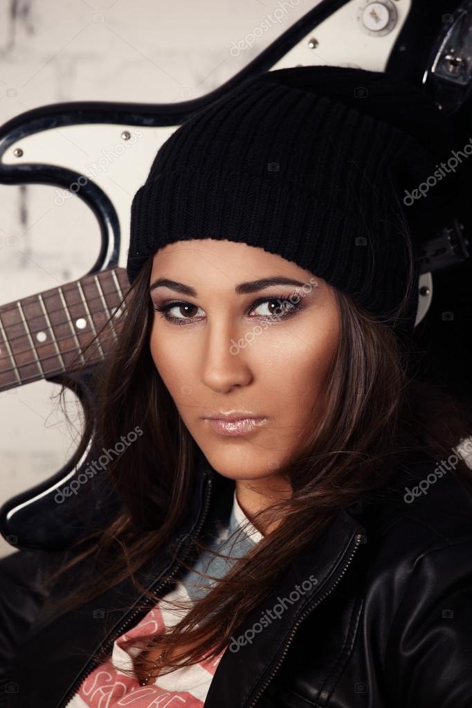 Retrato de una joven hermosa mujer músico sosteniendo su guitarra en su hombro — Foto de stock ...