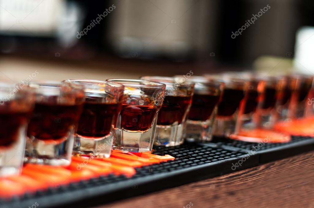 Bebida alcohólica fuerte y roja en vasos pequeños en el bar 2022