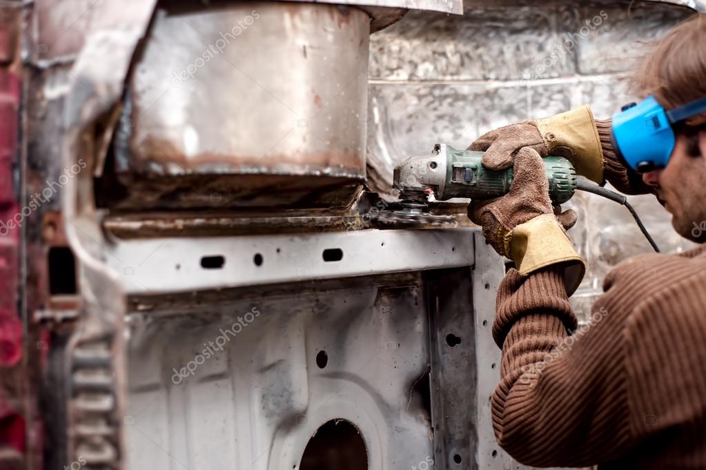 Professional welder in auto vehicle factory working on the body of a ...