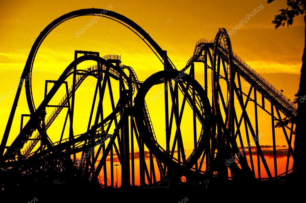 Silhouette of a roller coaster at sunset, after a sunny day at fair ...