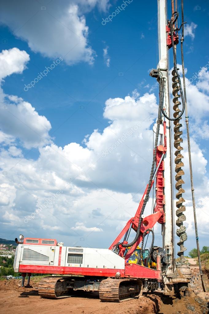 Industrial construction site with drilling rig making holes in the ...