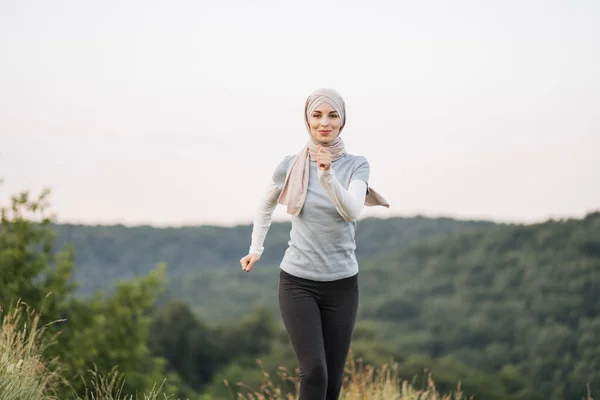 Jogging Arabic woman in hijab running in green park on beautiful summer ...