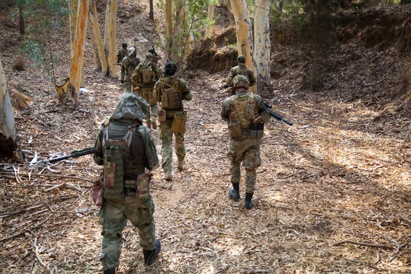 Un destacamento de jugadores de airsoft en camuflaje camina por el ...
