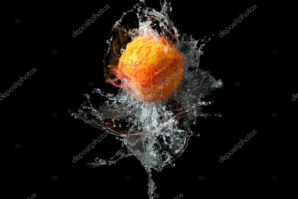 Melocotón en spray de agua sobre fondo negro 2022