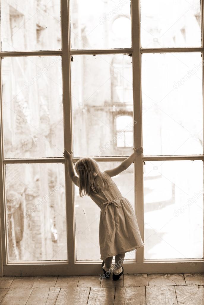 Young girl looking out a window Stock Photo by ©ellenamani 49332241