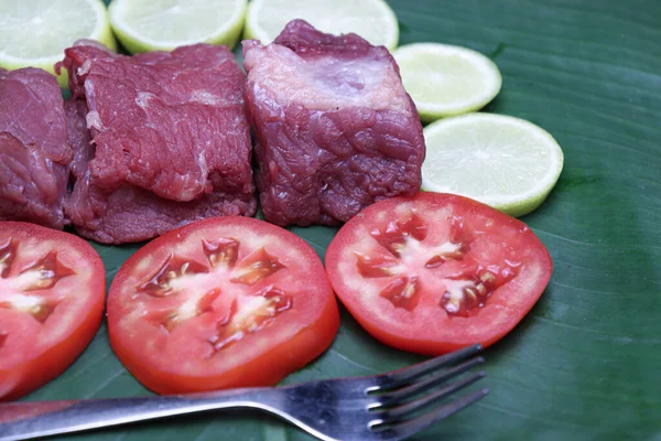 fresh tasty cow beef with sliced lemon and spoon on banana leaf - Stock ...