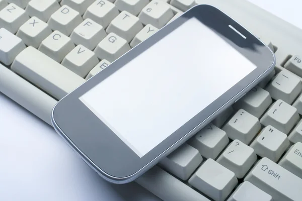 Mobile phone on a computer keyboard — Stock Photo © daboost #5011095