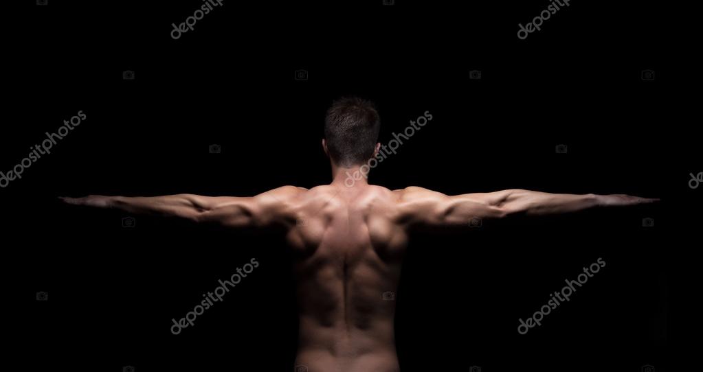 Muscular man with arms streched out on black background Stock Photo by ...