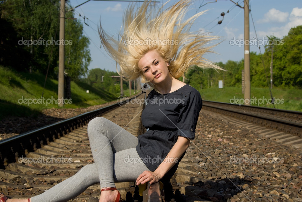 Girl blonde sitting on the rails — Stock Photo © m.ilias1987 #12407104