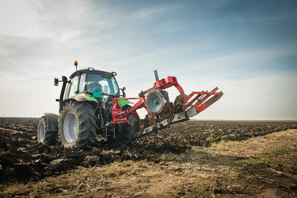 Tractor plowing a field — Stock Photo © fotokostic #95417362