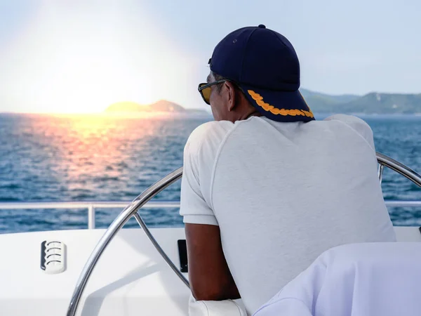 The boat captain had control the boat with yellow light background ...
