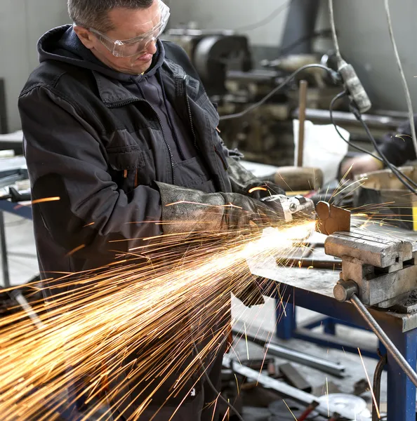 manual worker grinding metal table in production hall - Stock Image ...