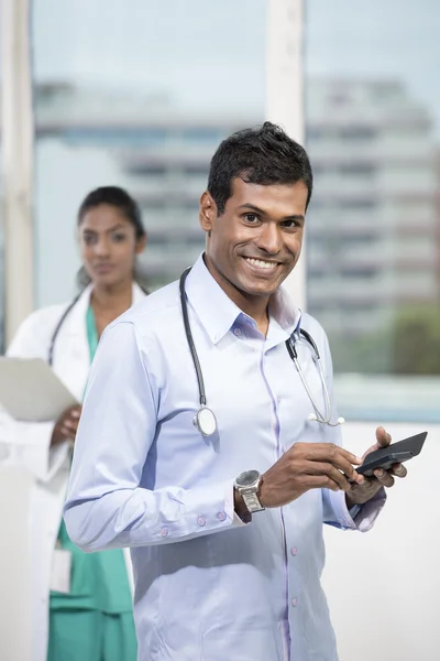 Portrait of a male Indian doctor using a smart phone - Stock Image ...