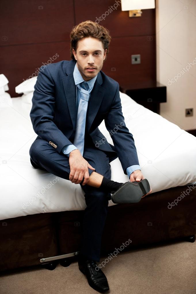 Tired businessman taking off his shoes Stock Photo by ©stockyimages ...