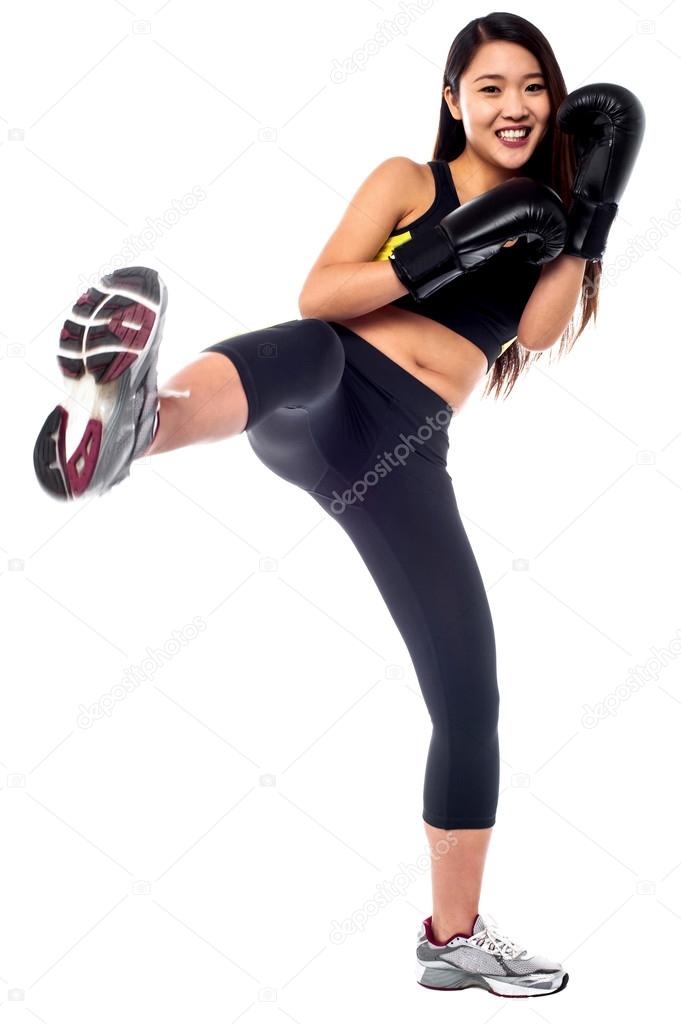 Fit slim girl practising kick boxing Stock Photo by ©stockyimages 27649353