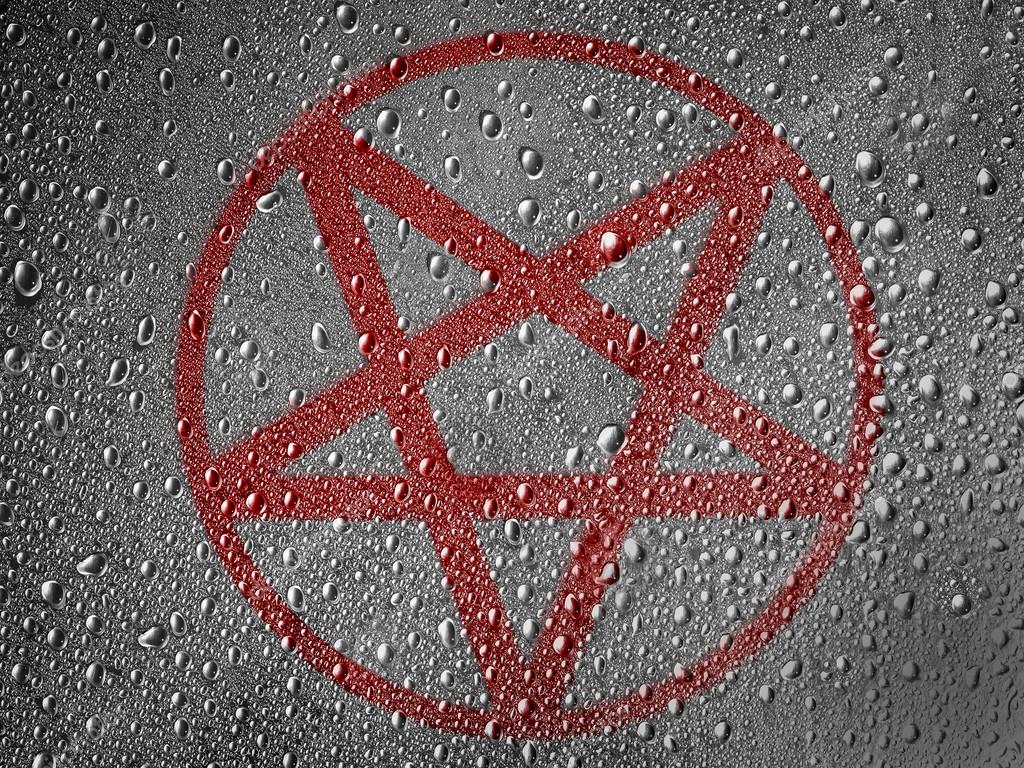 Pentagram symbol painted on metal surface covered with rain drops ...