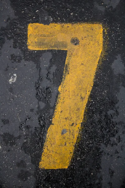 evocative image of the number seven painted on the concrete of a ...