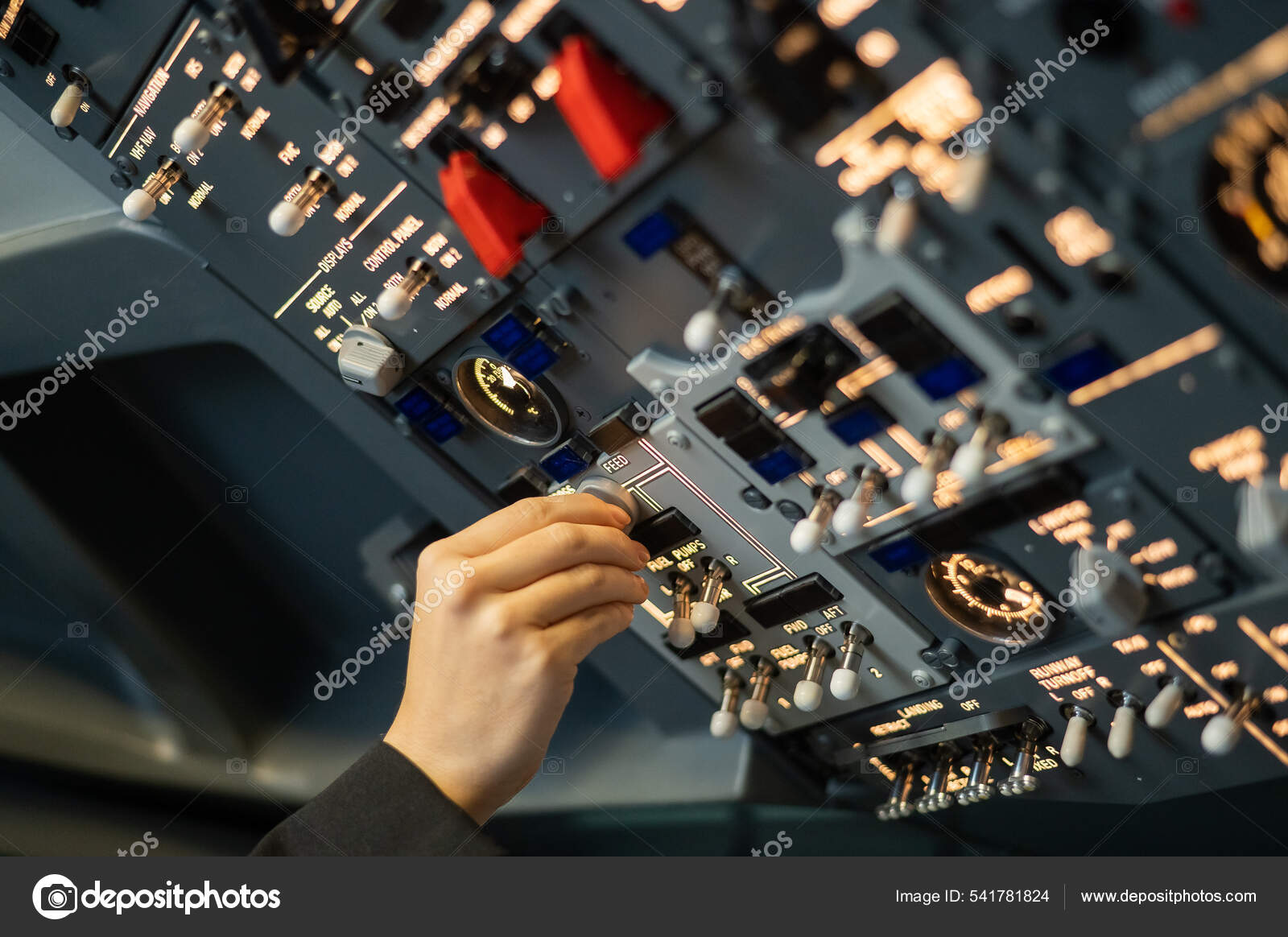 Close-up of a pilots hand turning a toggle switch on the control panel ...