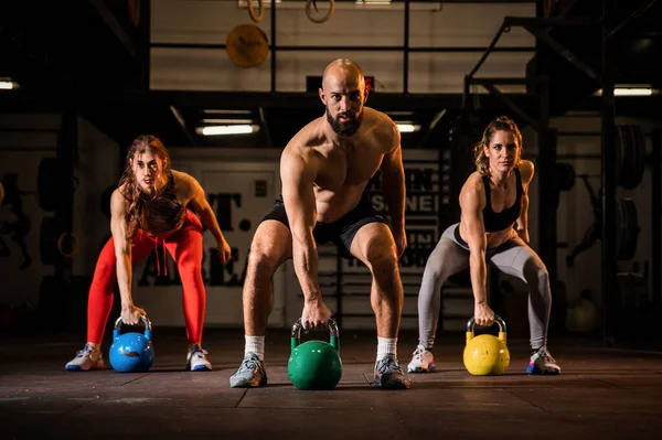 Fit group people in exercise gear standing in a row holding dumbbells ...