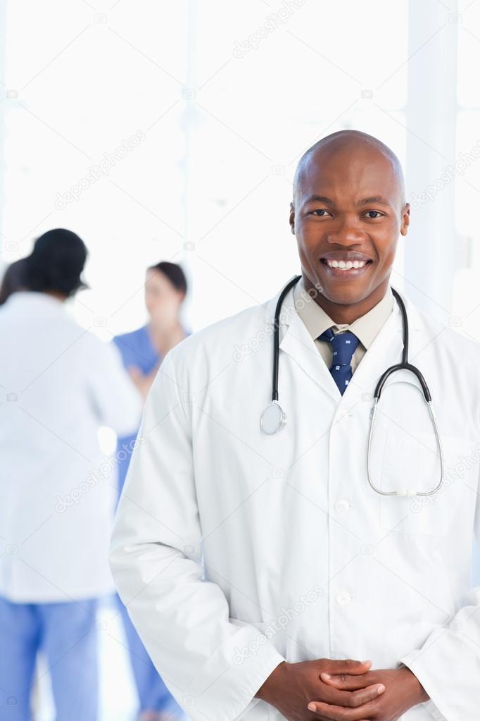 Joven doctor usando una corbata bajo su bata blanca de laboratorio 2022