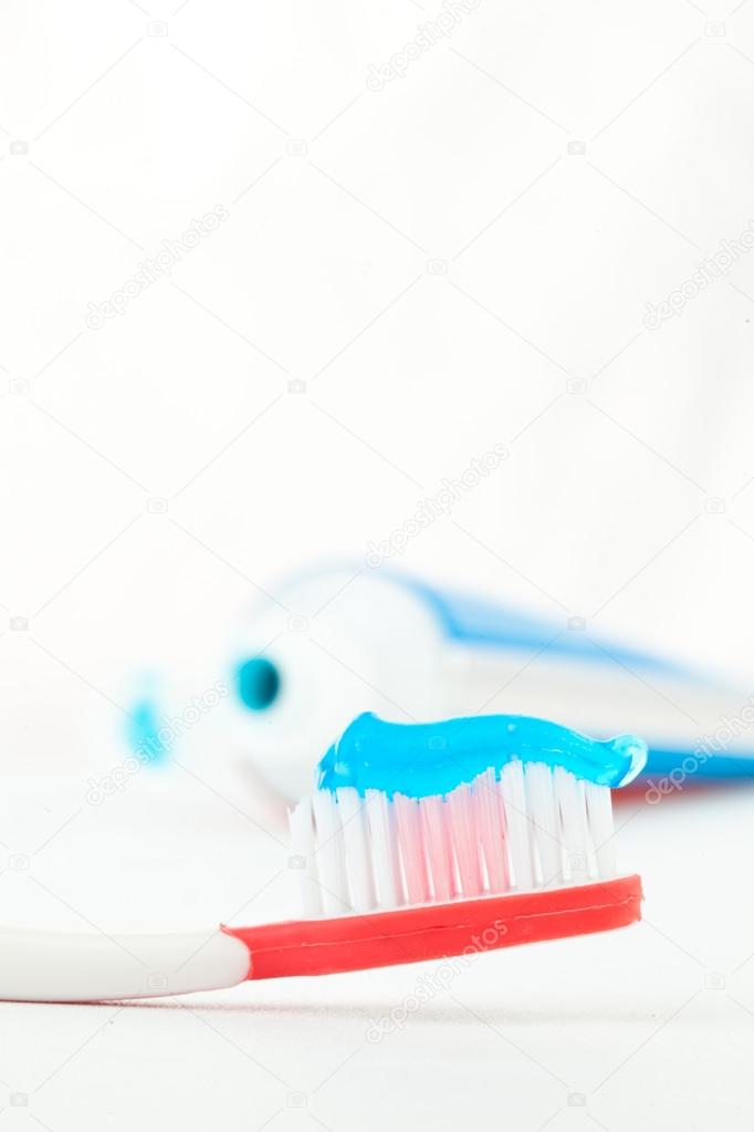 Red toothbrush next to a tube of toothpaste Stock Photo by ...