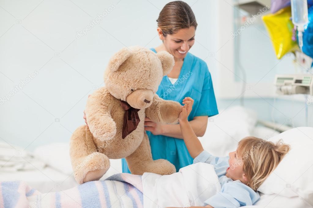 Nurse showing a teddy bear to a child Stock Photo by ©Wavebreakmedia ... Nurse showing a teddy bear to a child Stock Photo by ©Wavebreakmedia ...