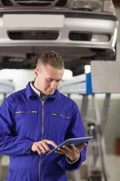 Concentrated mechanic holding a tablet computer - Stock Image - Everypixel