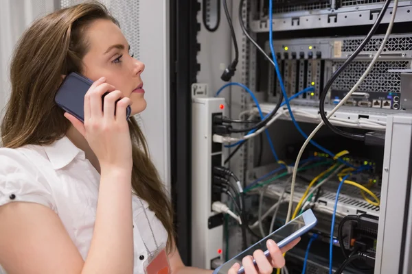 Woman working on servers with tablet pc on the phone - Stock Image ...