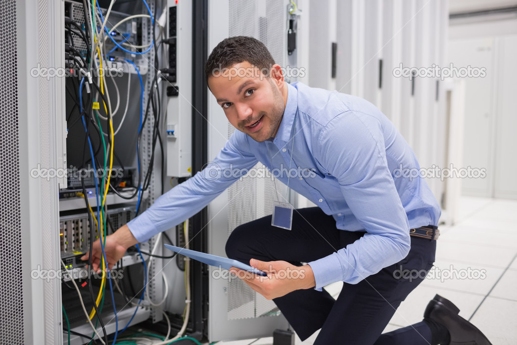 Técnico sonriente con tableta PC cables de conexión en el servidor 2022