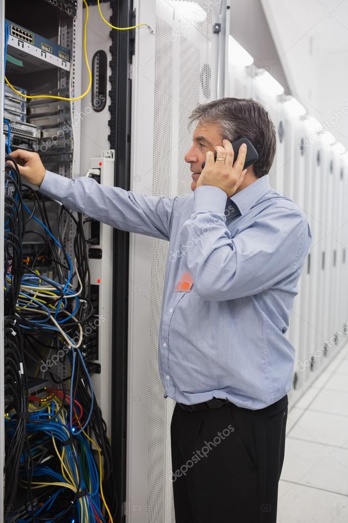 Male technician phoning while repairing a server Stock Photo by ...