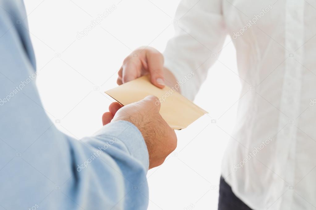 Businessman handing over envelop to coworker — Stock Photo ...