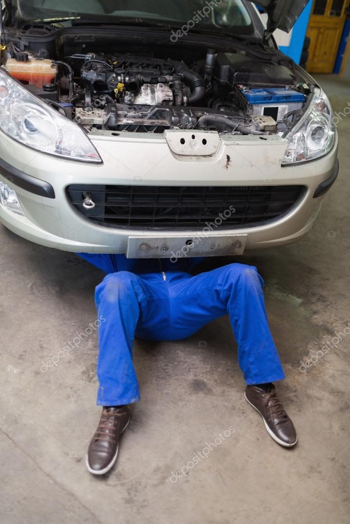 Male mechanic lying under car — Stock Photo © Wavebreakmedia #24093935